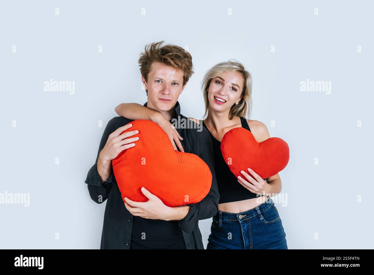 Happy couple loving together holding a red heart Stock Photo - Alamy