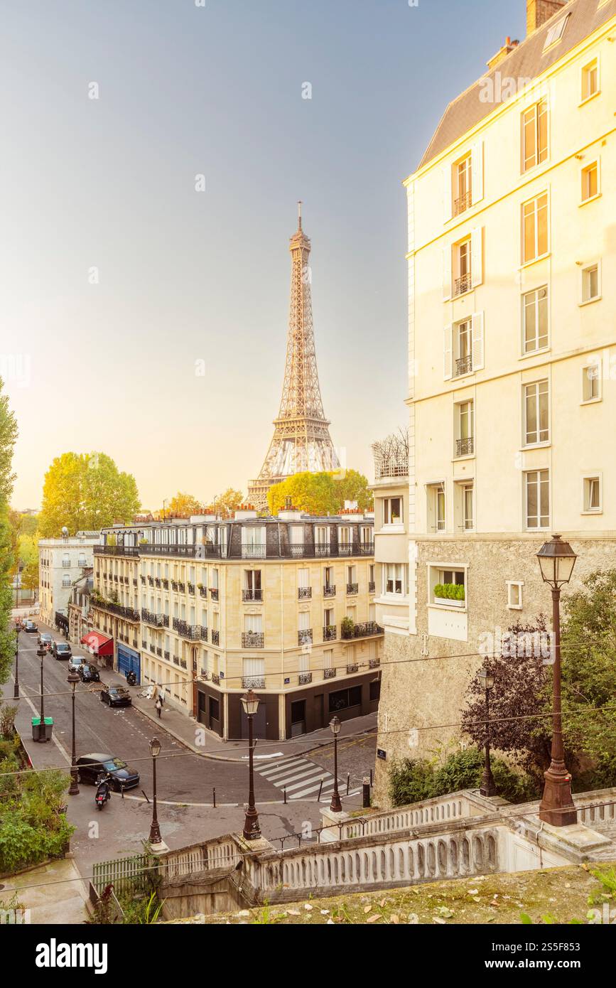 Parisian street view at dusk with the Eiffel Tower in the background ...