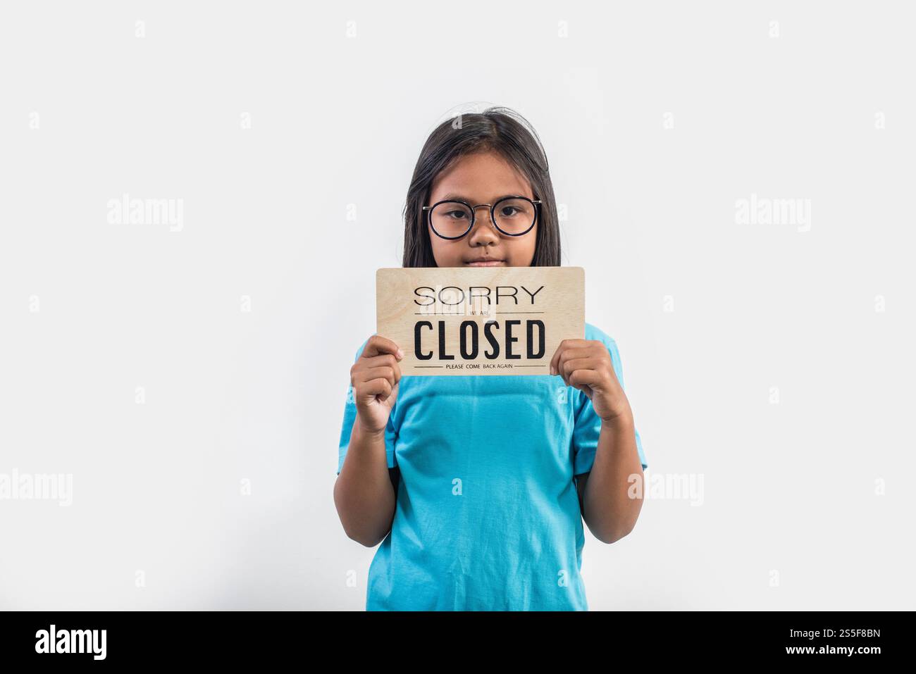 Little girl hand holding wood sign "closed Stock Photo - Alamy