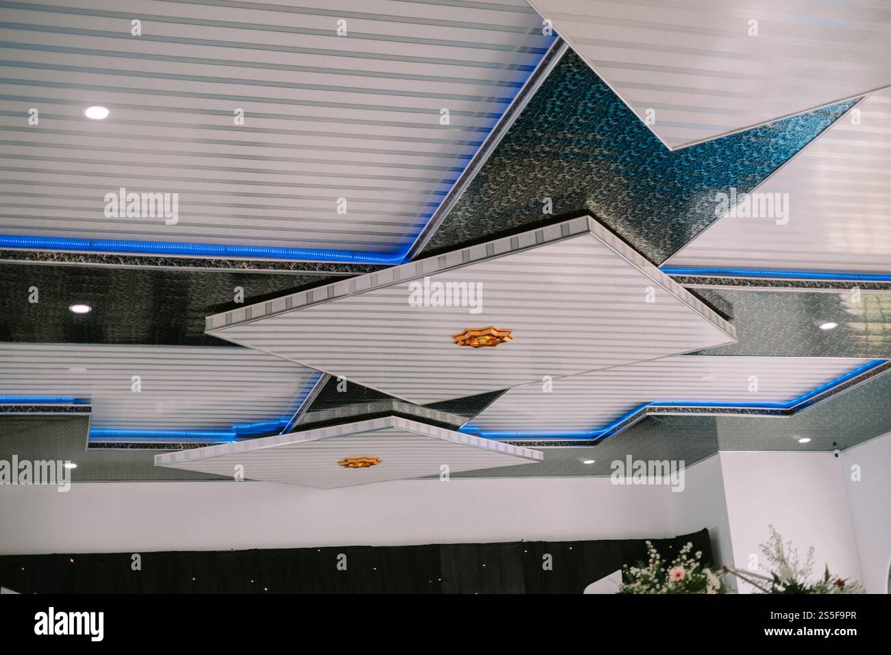 A contemporary ceiling featuring geometric panels, integrated lighting ...