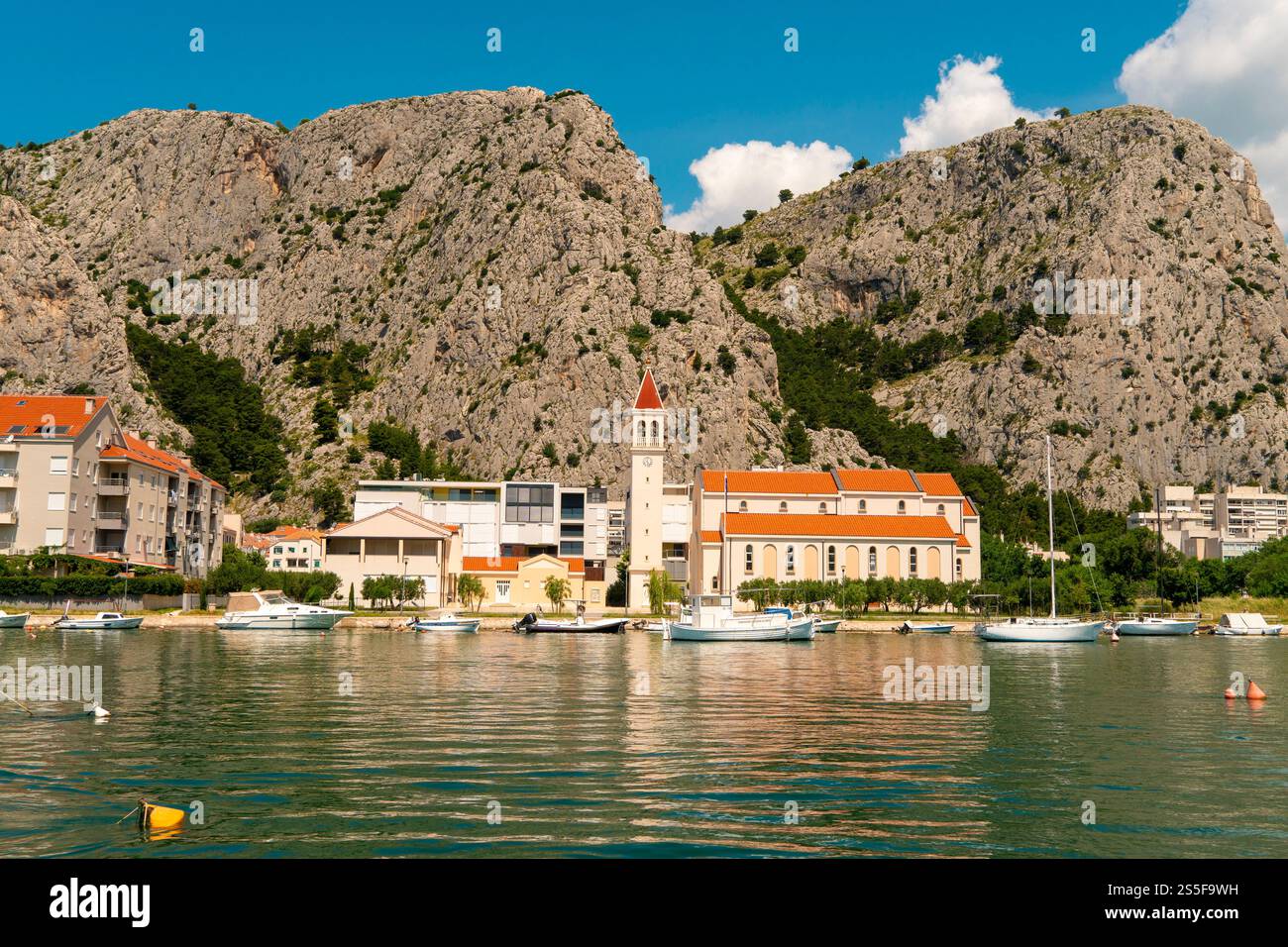 Coastal town of Omis with orange-roofed buildings nestled at the foot ...