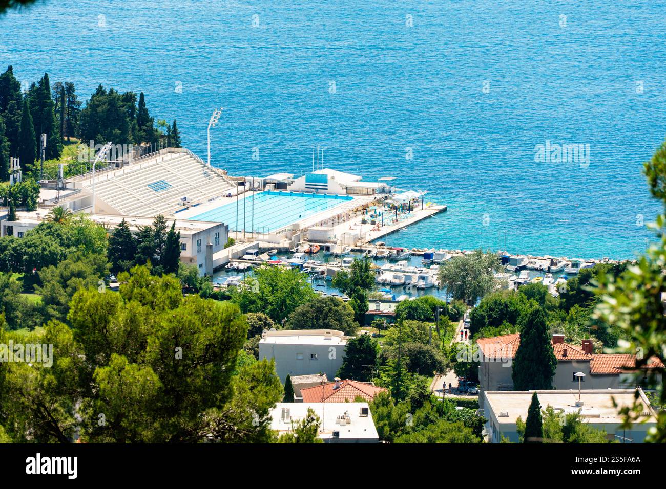 Aerial view of an outdoor olympic swimming pool, boats docked in a ...