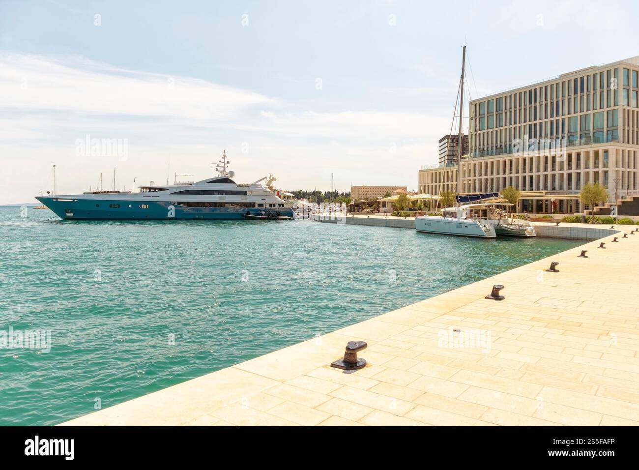 Luxury yachts moored at a modern marina with clear blue skies and calm ...