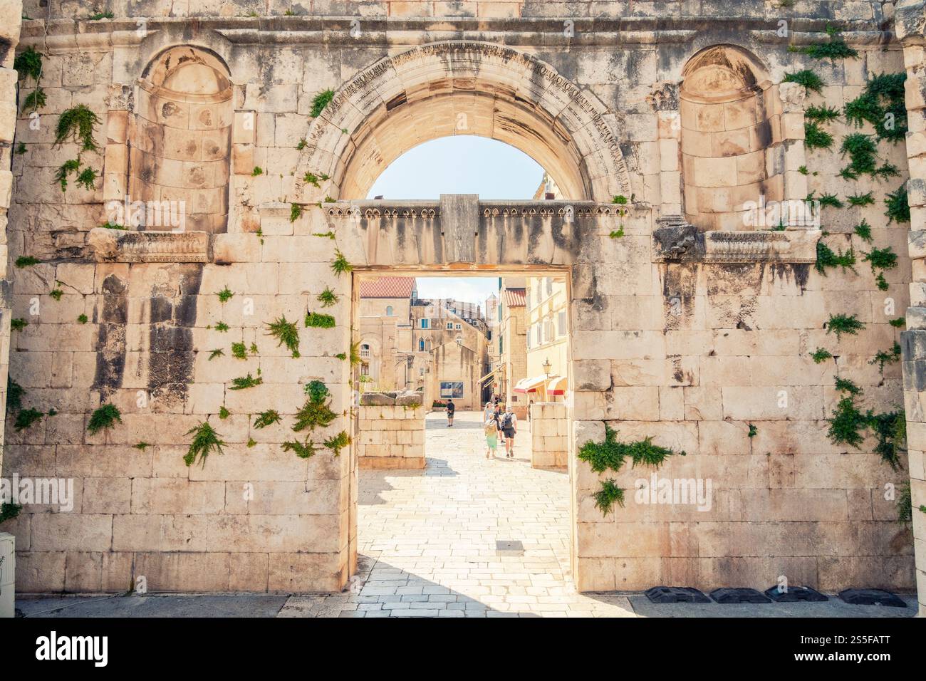 Ancient stone archway silver gate leading to a cobbled street with ...