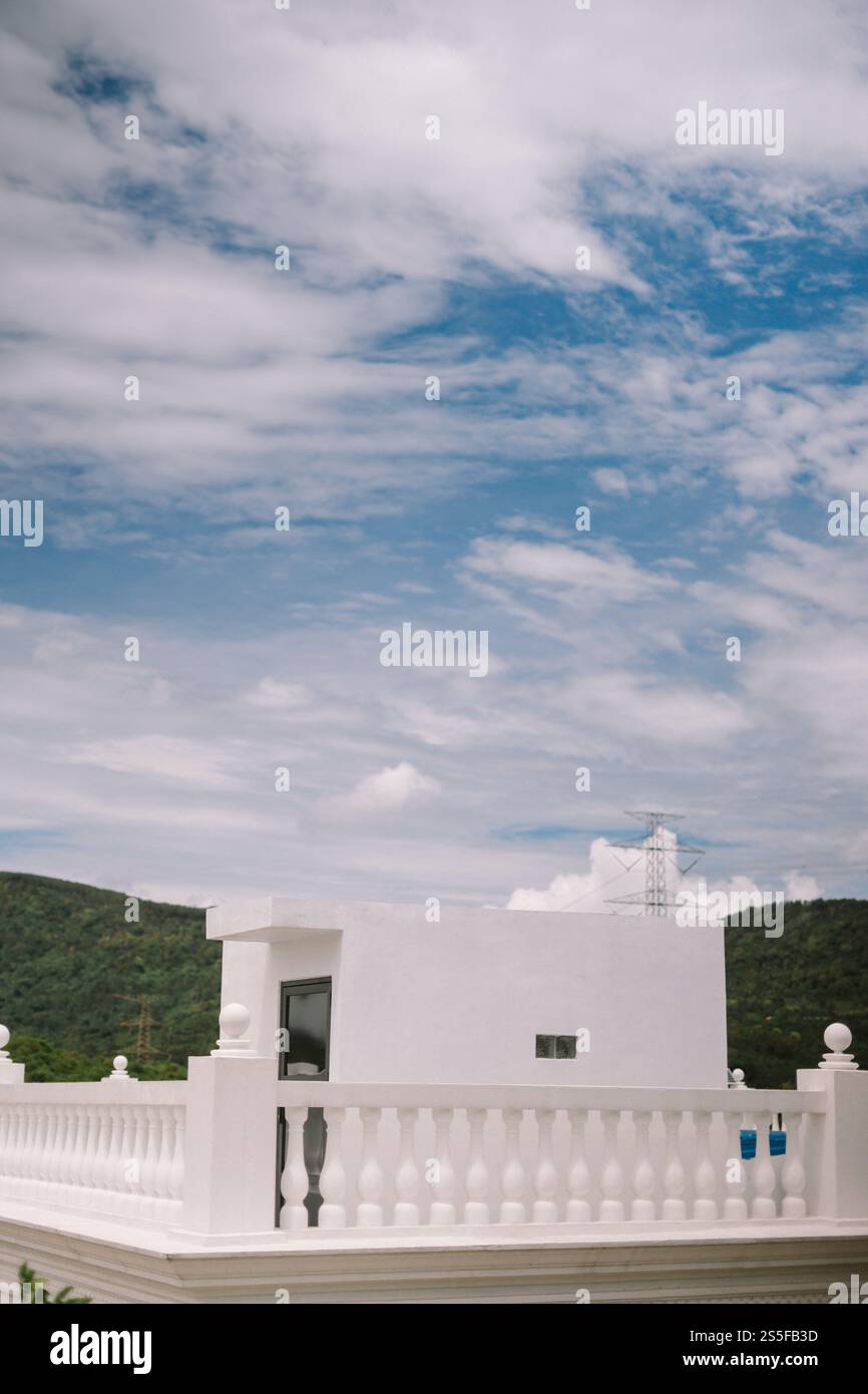 A minimalist white rooftop structure with a classic balustrade against ...