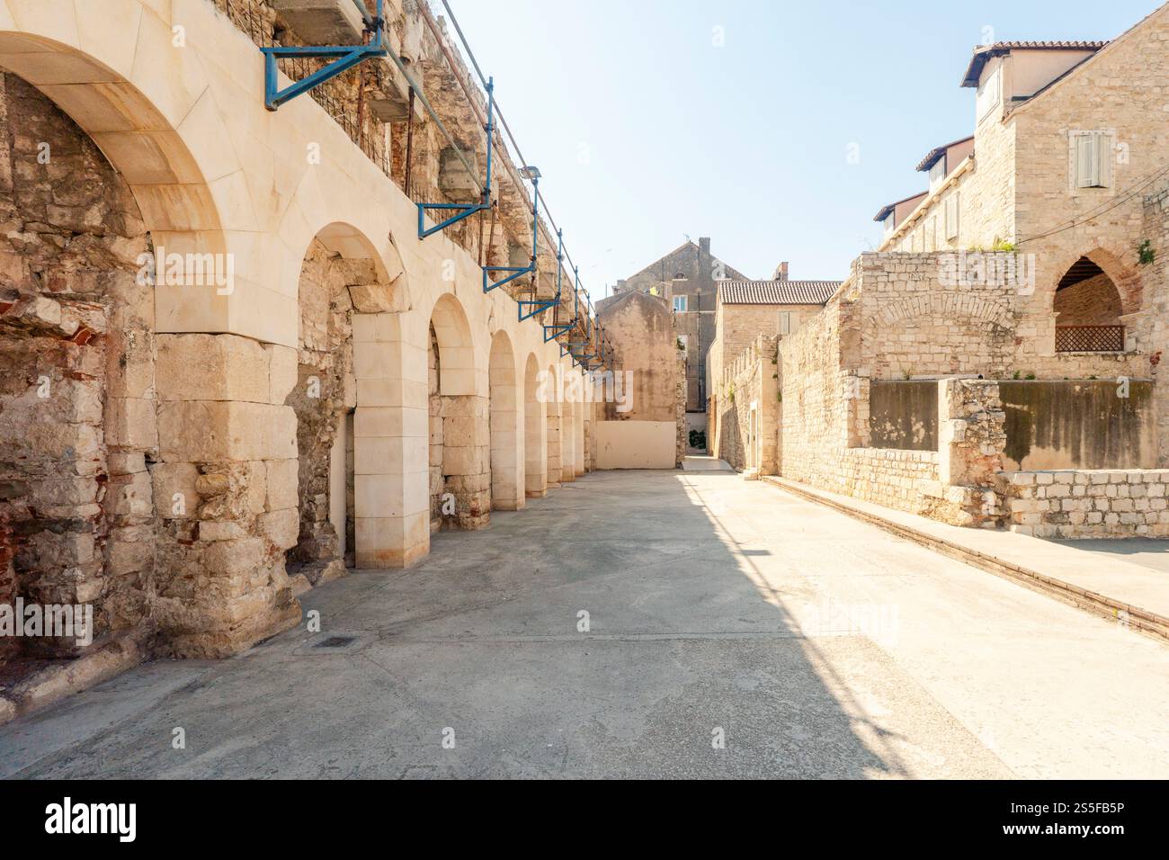 Sunlit cobblestone alley flanked by old buildings and Ethnographic ...