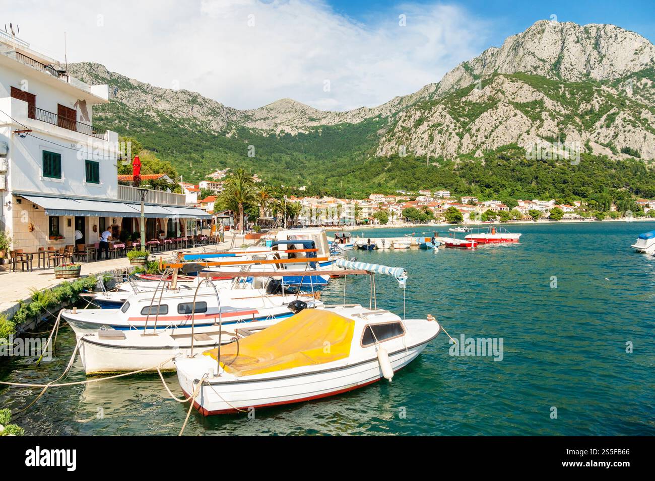 Coastal town Drvenik with boats moored in a clear blue harbor, against ...
