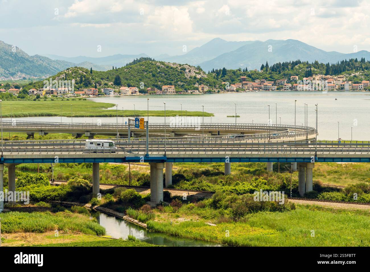 Curved bridge over tranquil river white bus driving across hi-res stock ...