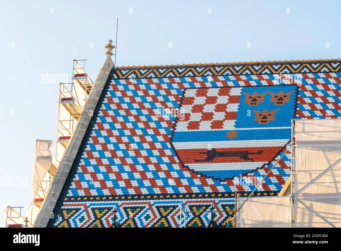 Colorful mosaic-tiled roof the Saint Mark's Church against a clear blue ...