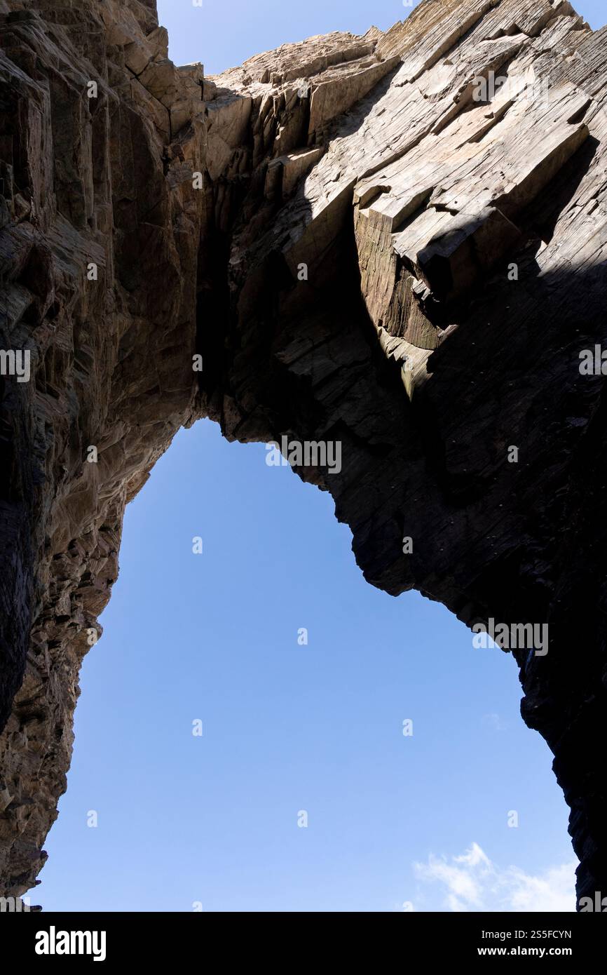 Natural rock arch viewed from below, highlighting rugged textures and ...