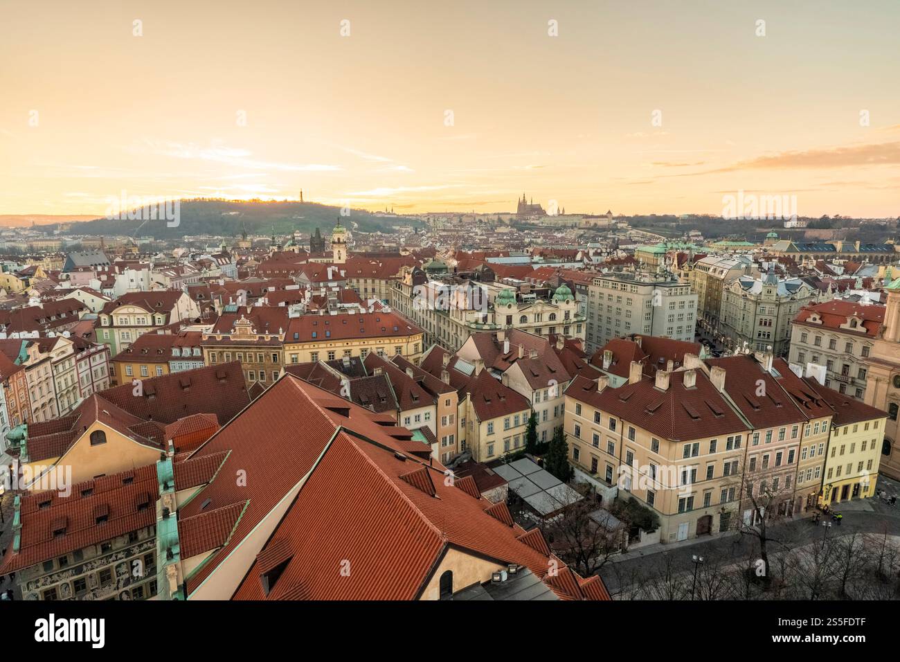 Sunset bathes the historic rooftops and architecture of Prague in warm ...