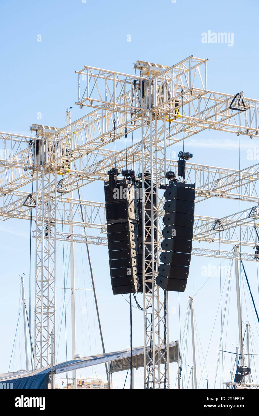 Outdoor concert stage with large speakers suspended on a metal truss ...