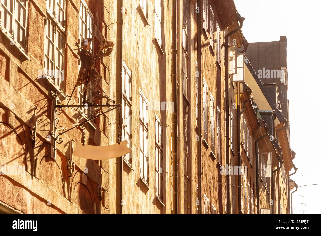 Warm sunlight illuminates a quaint antique shop sign on a rustic ...