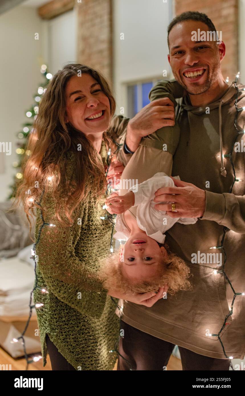 Lifting ecstatic child upside down cozy indoor setting hi-res stock ...