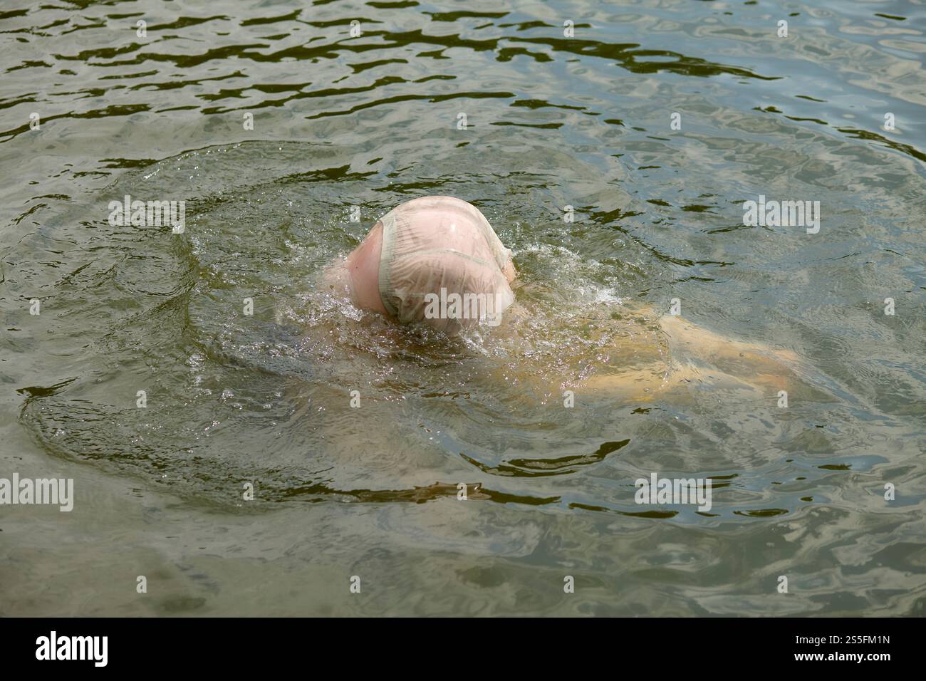 A person is submerged in water with only the butt visible above the ...