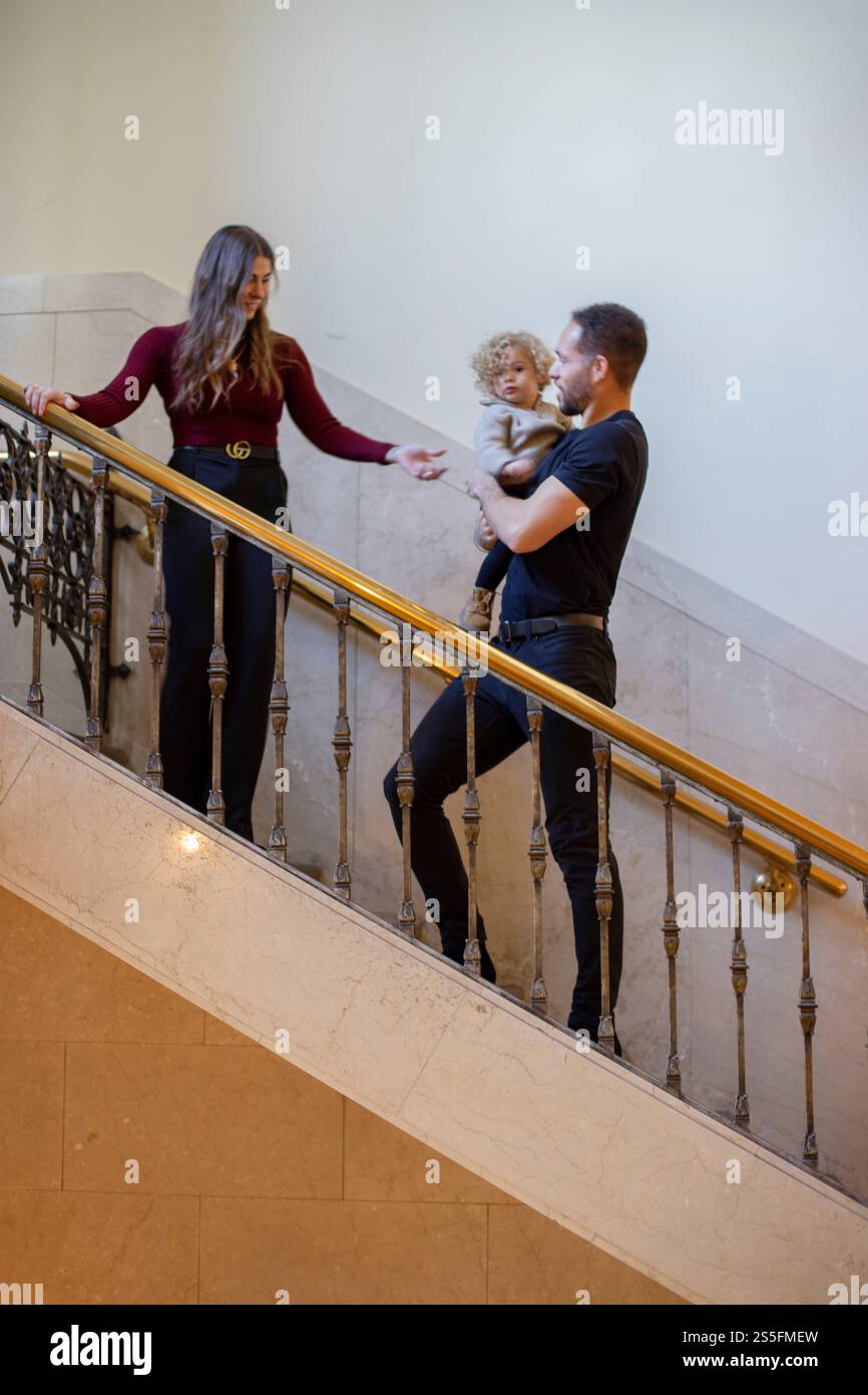 Family moment with a mother reaching out to her child held by the ...