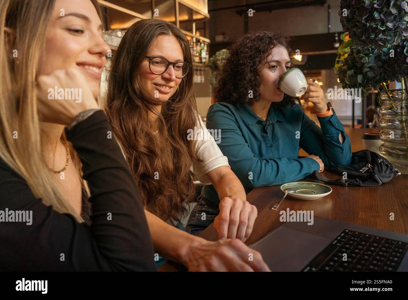 Three women enjoy conversation coffee cafe table hi-res stock ...