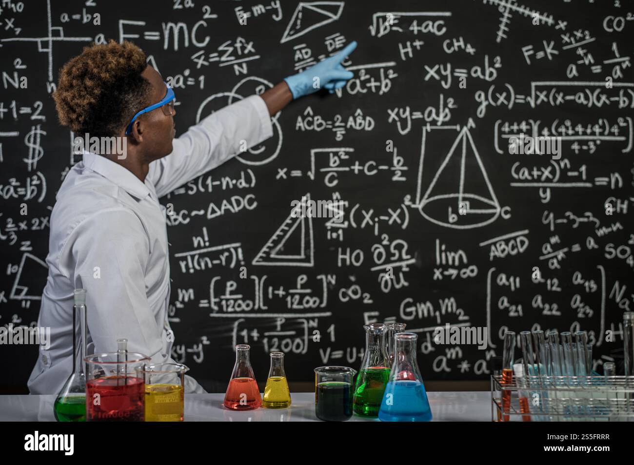 Scientists wear glasses and point to formulas on the blackboard in the ...