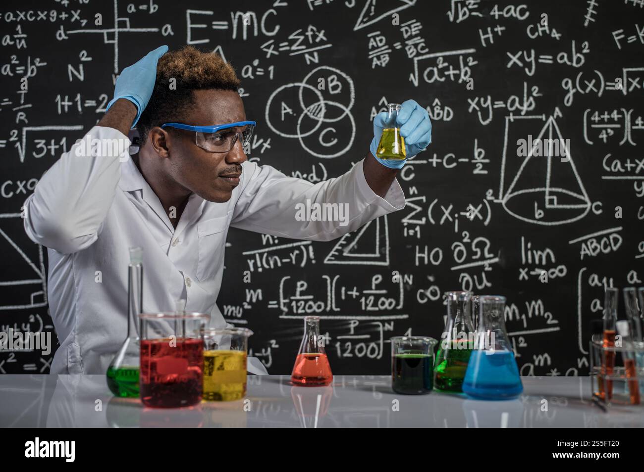 Scientists look at the yellow chemical in the glass and the handle of ...