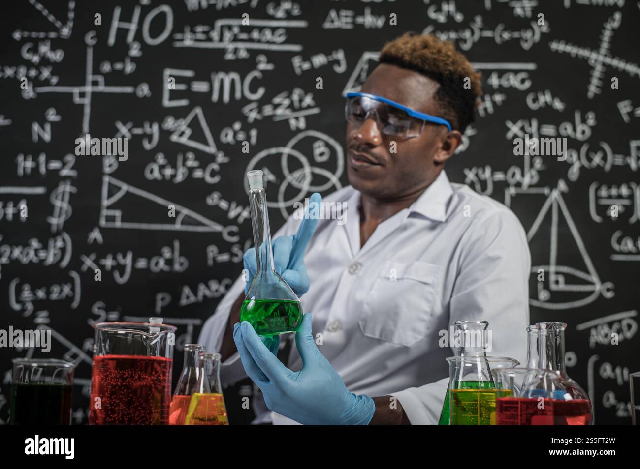 Scientists use the idea and hold the beaker with green chemicals in the ...