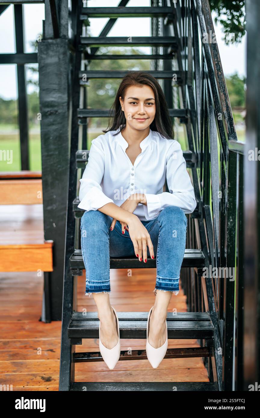 The woman sat on the stairs and looked to the front Stock Photo - Alamy