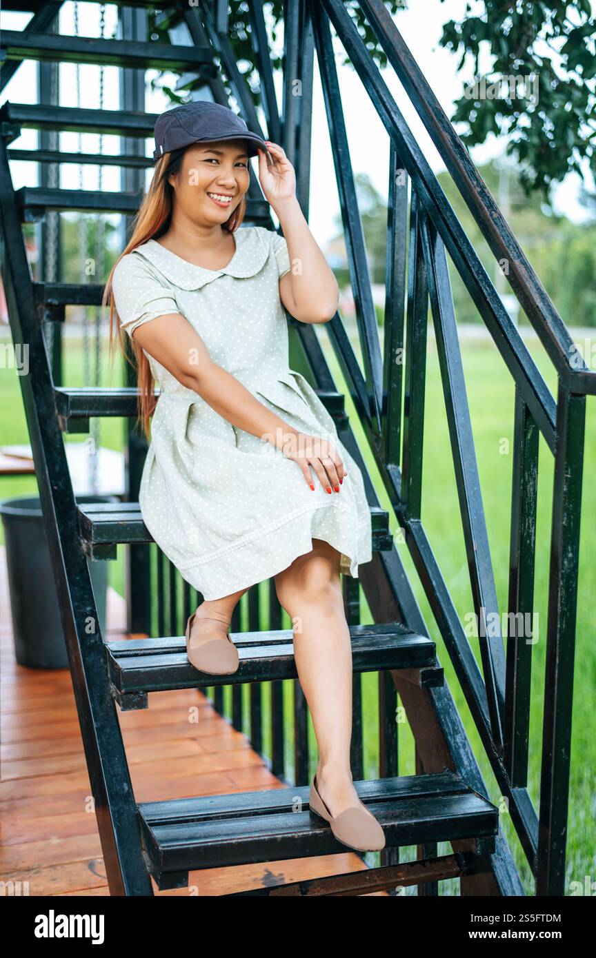 The woman sat happily on the stairs and the handle on the hat Stock ...