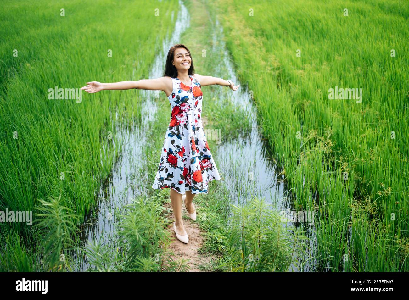 Beautiful woman walking in field Stock Photo - Alamy