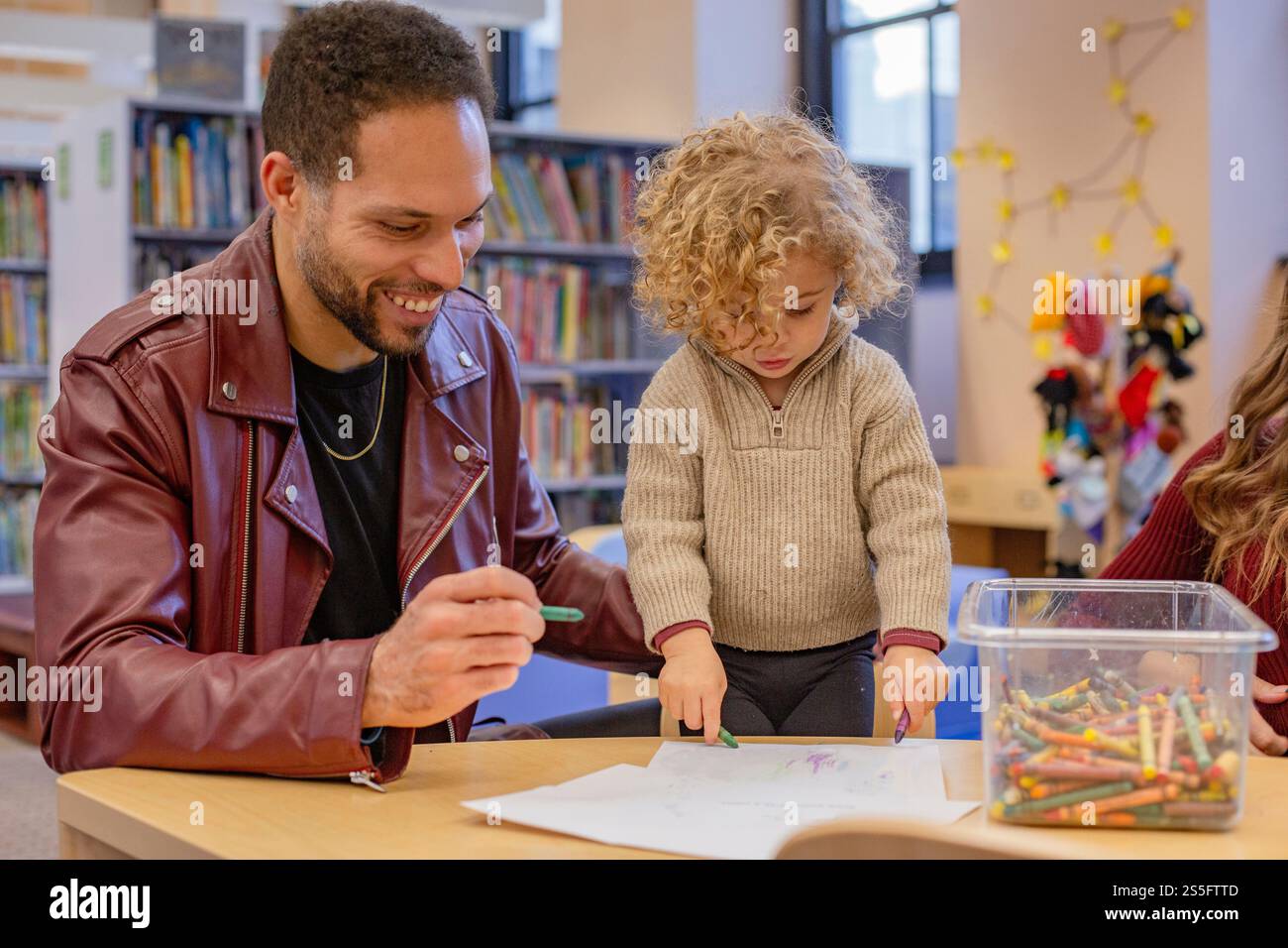 Adult male and young child engaged in drawing together with colorful ...