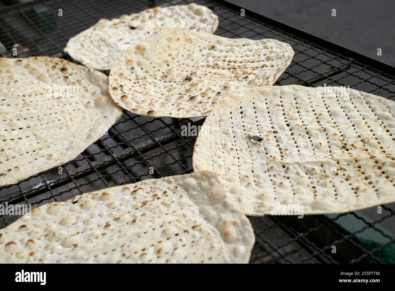 Freshly baked traditional Iranian flatbread cooling on a wire mesh ...
