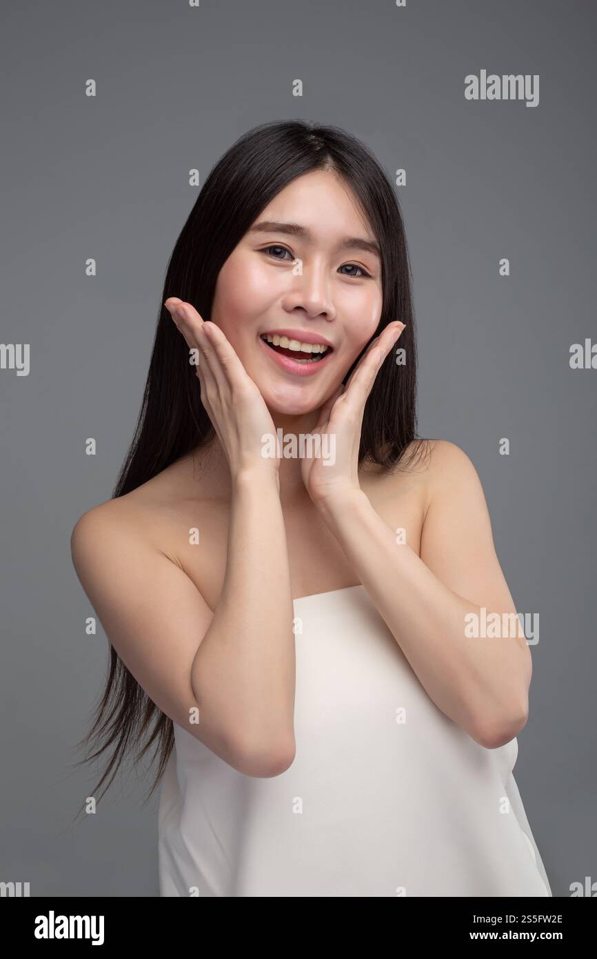 The woman wore a white strapless dress and hands touch her face Stock ...