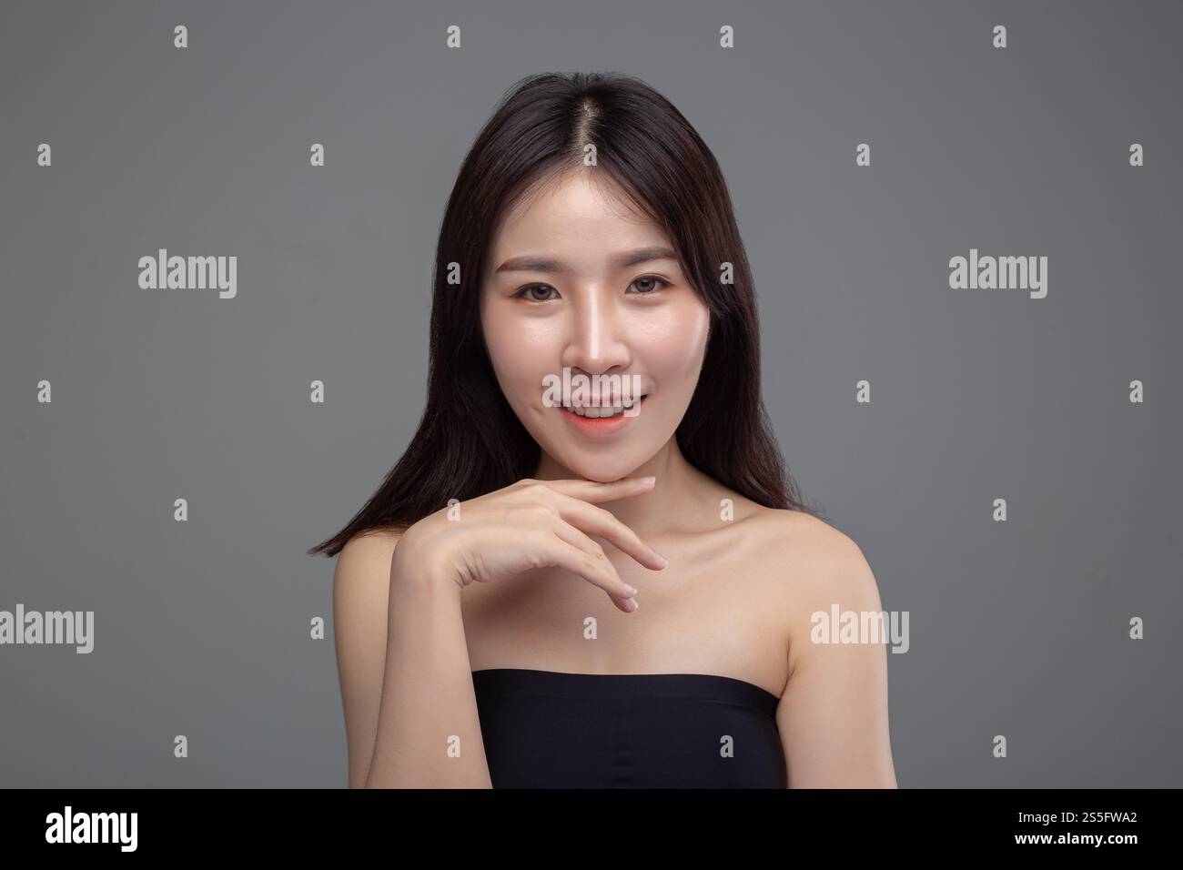 Woman wearing a black strapless dress and hands touching the chin Stock ...