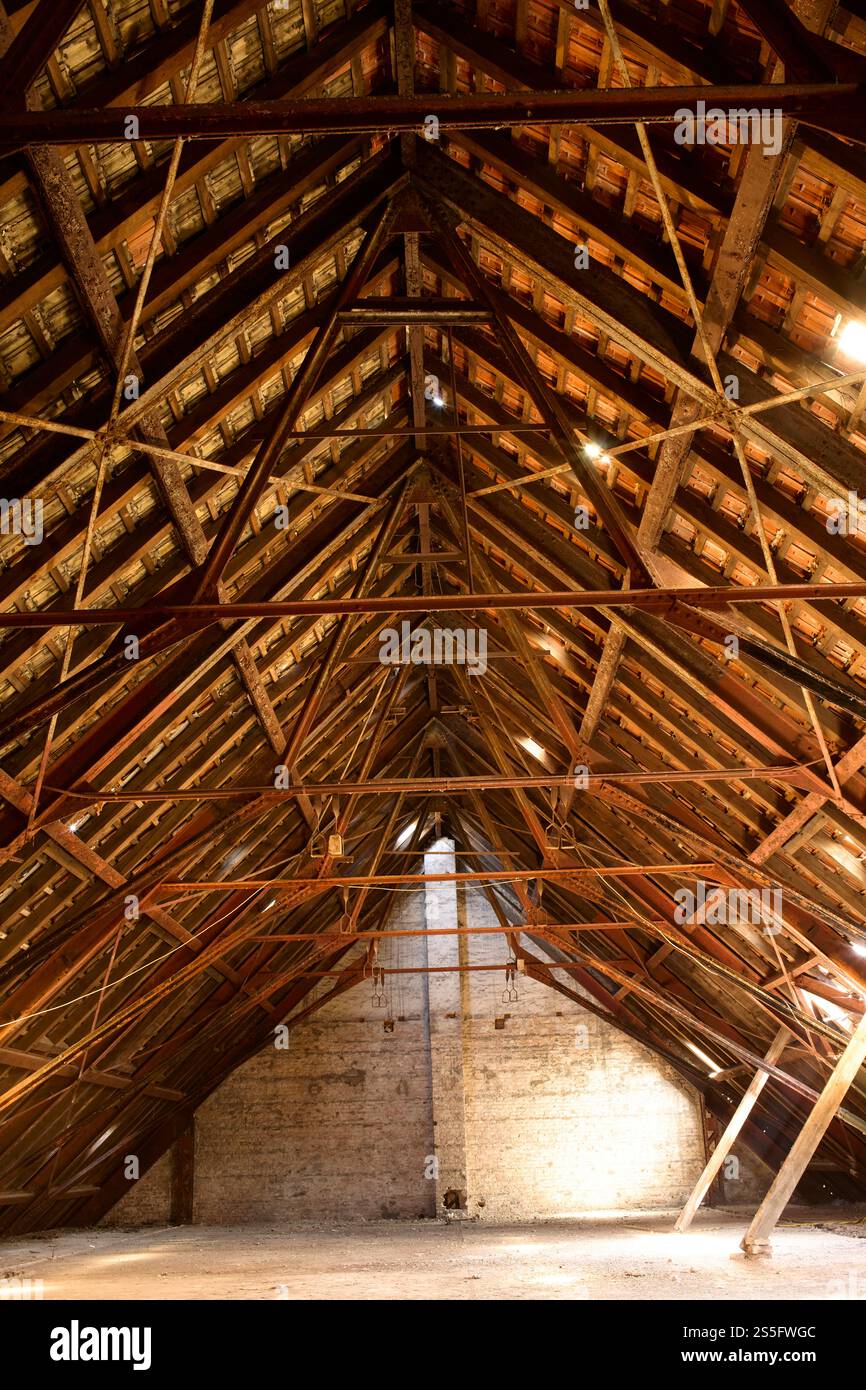 Wooden beams form a complex triangular structure in the attic of a ...
