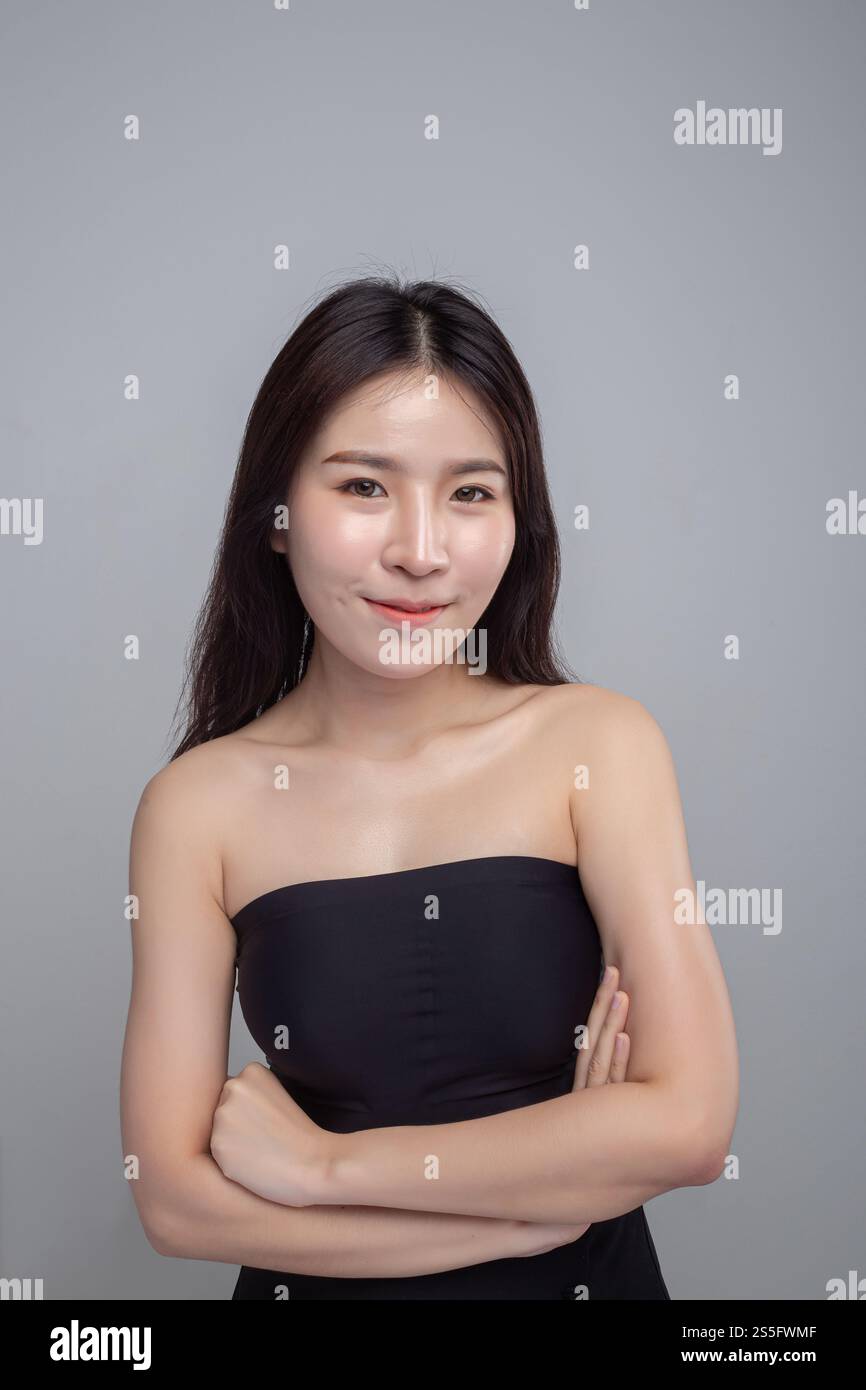 The woman is wearing a strapless shirt that stands with her arms ...