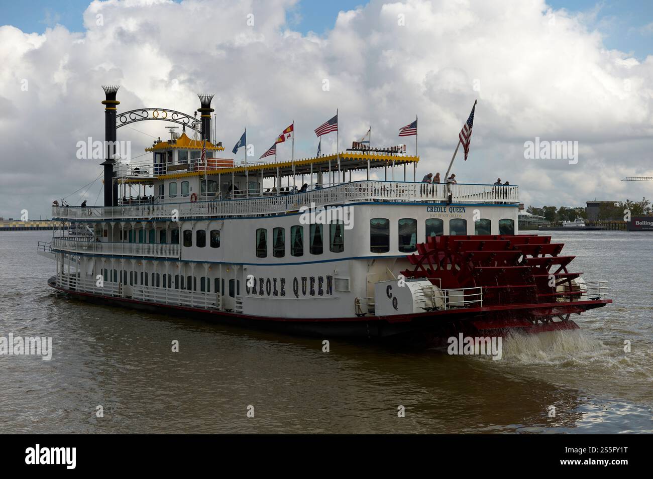 A riverboat named Creole Queen with a red paddle wheel floats on a body ...