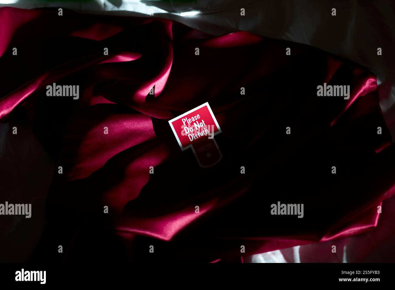 Red silk robe with a Please Do Not Disturb door tag on it under ...