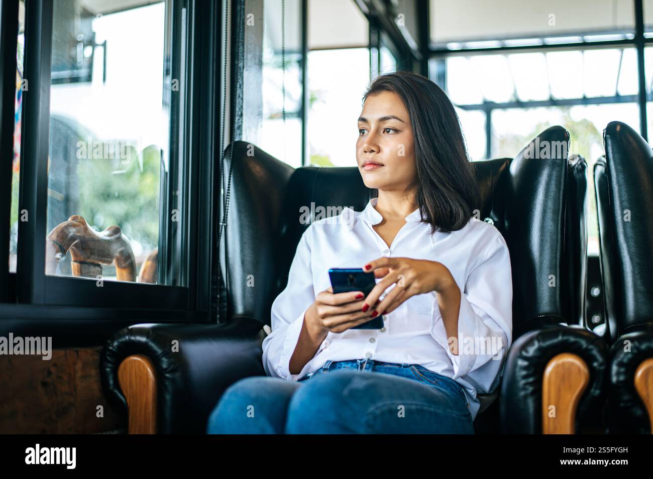 woman wearing white clothes and sitting play smartphone Stock Photo - Alamy