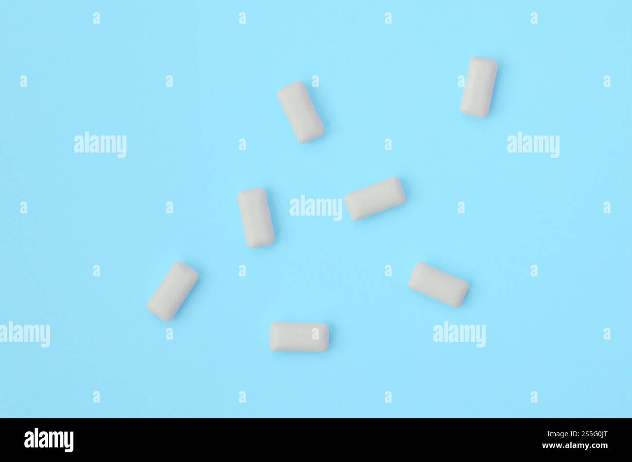 A few chewing gums lie on texture background of fashion pastel blue ...