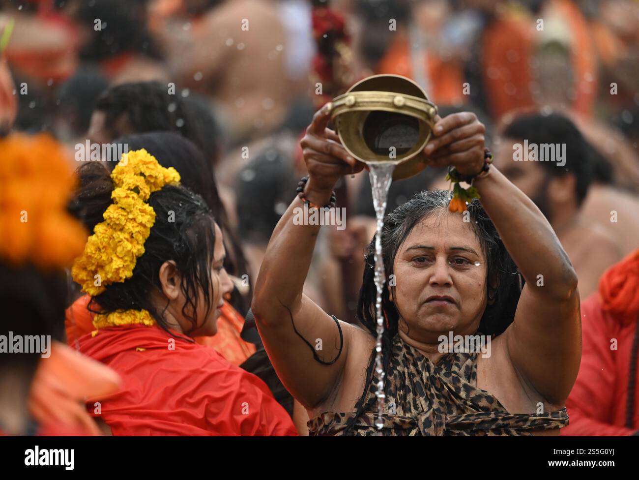 PRAYAGRAJ, INDIA - JANUARY 14: Female Sanyasini offering water during ...
