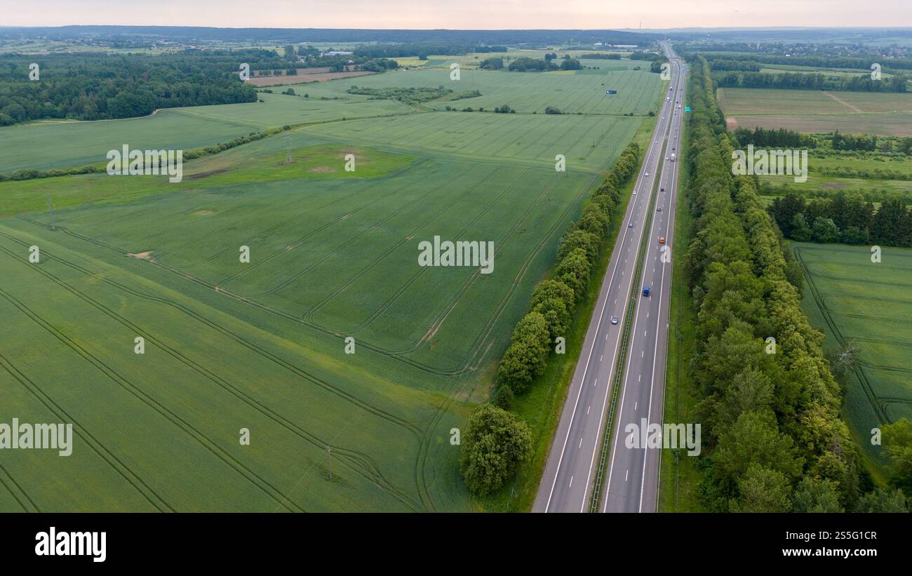 Aerial view of a straight highway running through vast green fields and forests Stock Photo - Alamy