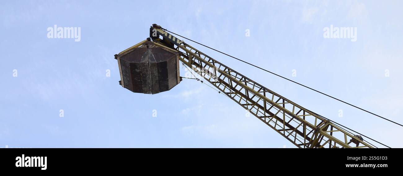 Old yellow mechanical clamshell grab on blue sky background Stock Photo ...