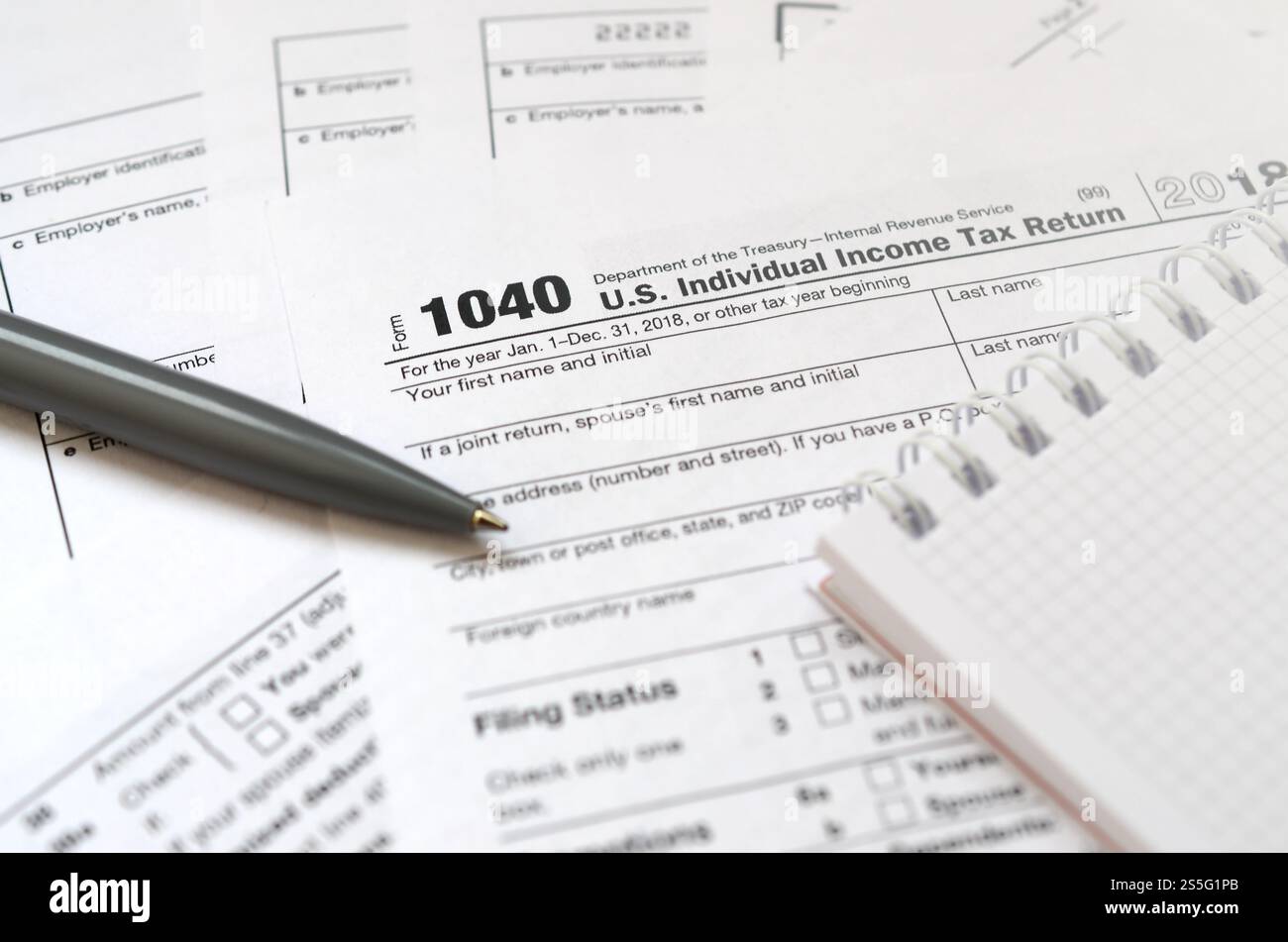 The pen and notebook is lies on the tax form 1040 U.S. Individual ...