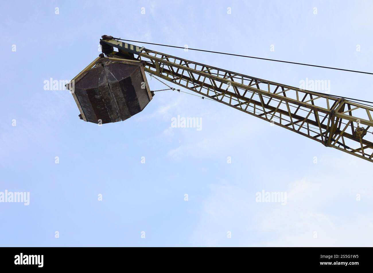 Old yellow mechanical clamshell grab on blue sky background Stock Photo ...
