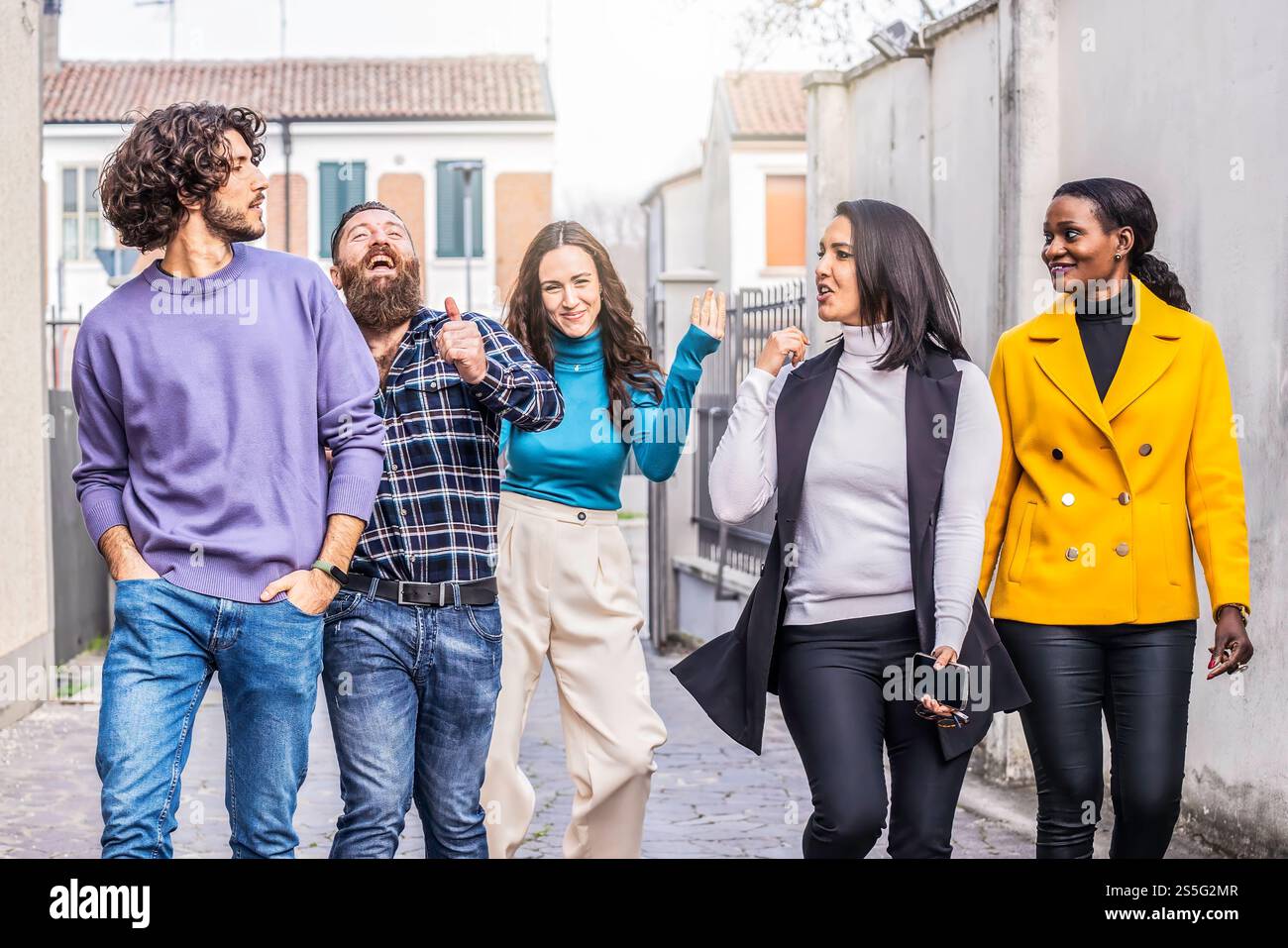 Multicultural and multiethnic friends walking and talking outdoors. A ...