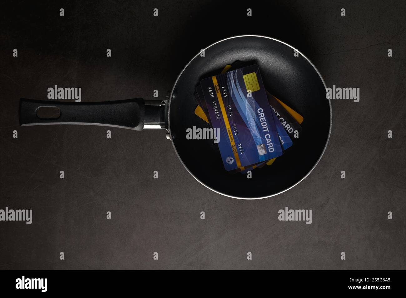 Place the credit card in the pan on a black background Stock Photo - Alamy