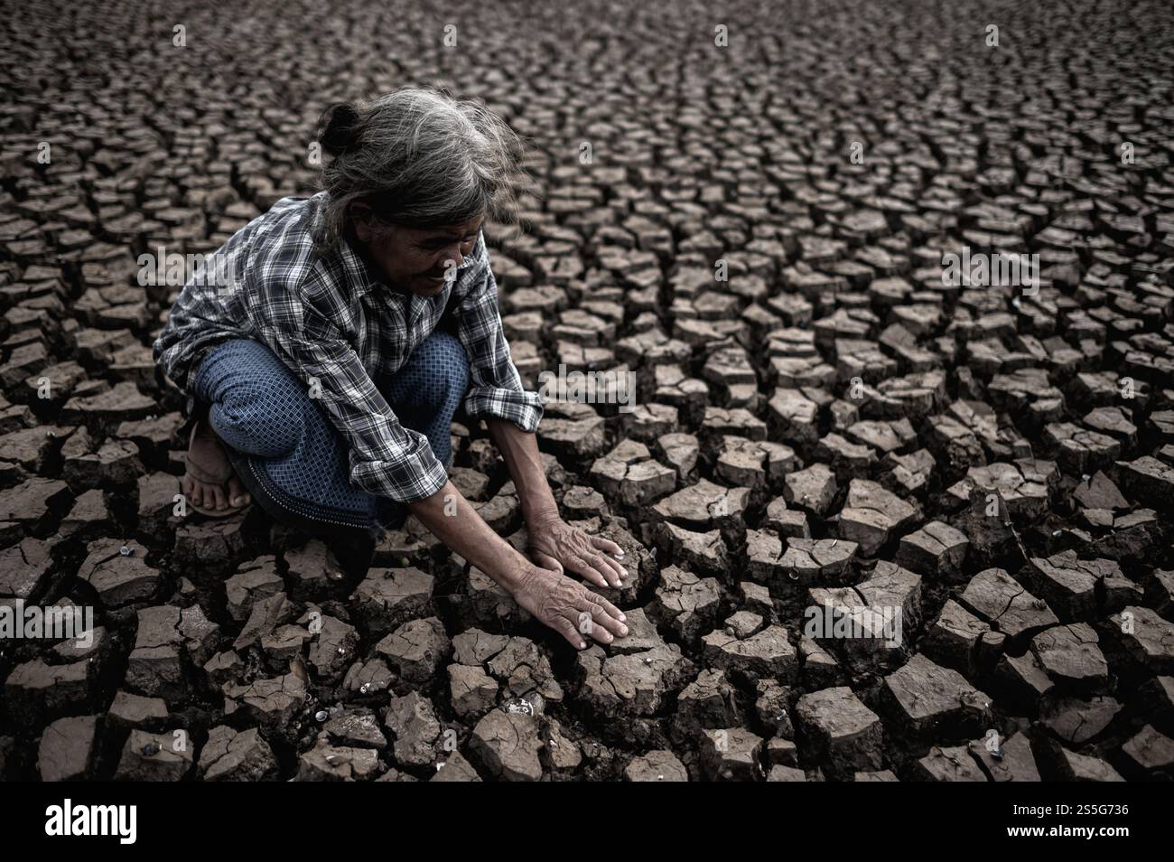 Elderly women are sitting looking at their hands, touching the ground ...