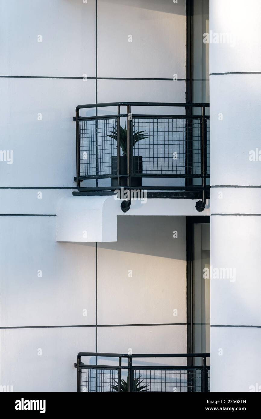 Minimalist balcony extends from a modern, white building. Balcony made ...