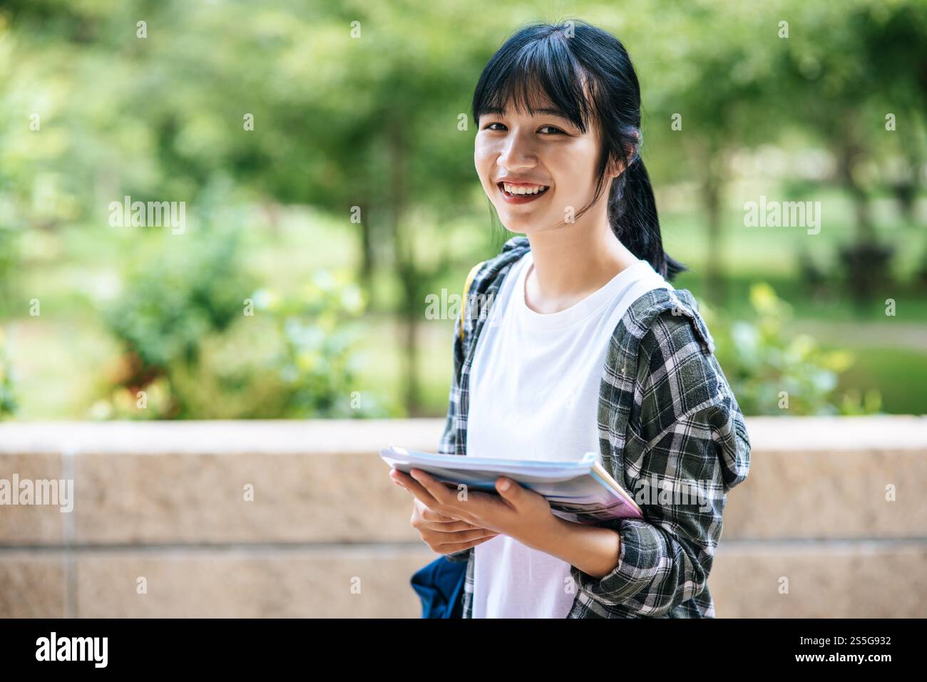 Female students stand on the stairs and hold books Stock Photo - Alamy