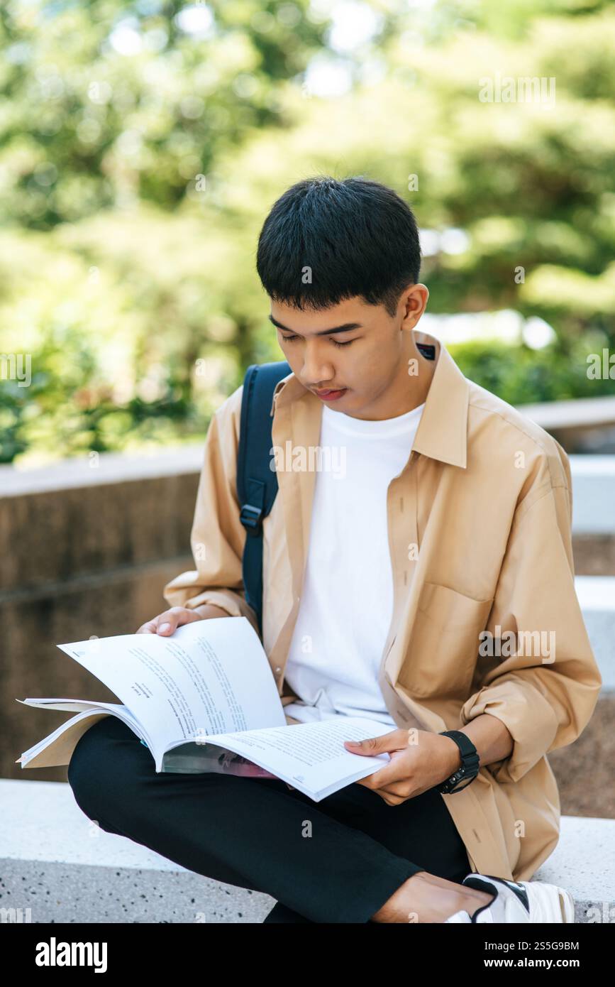 A man sitting and reading a book on the stairs Stock Photo - Alamy