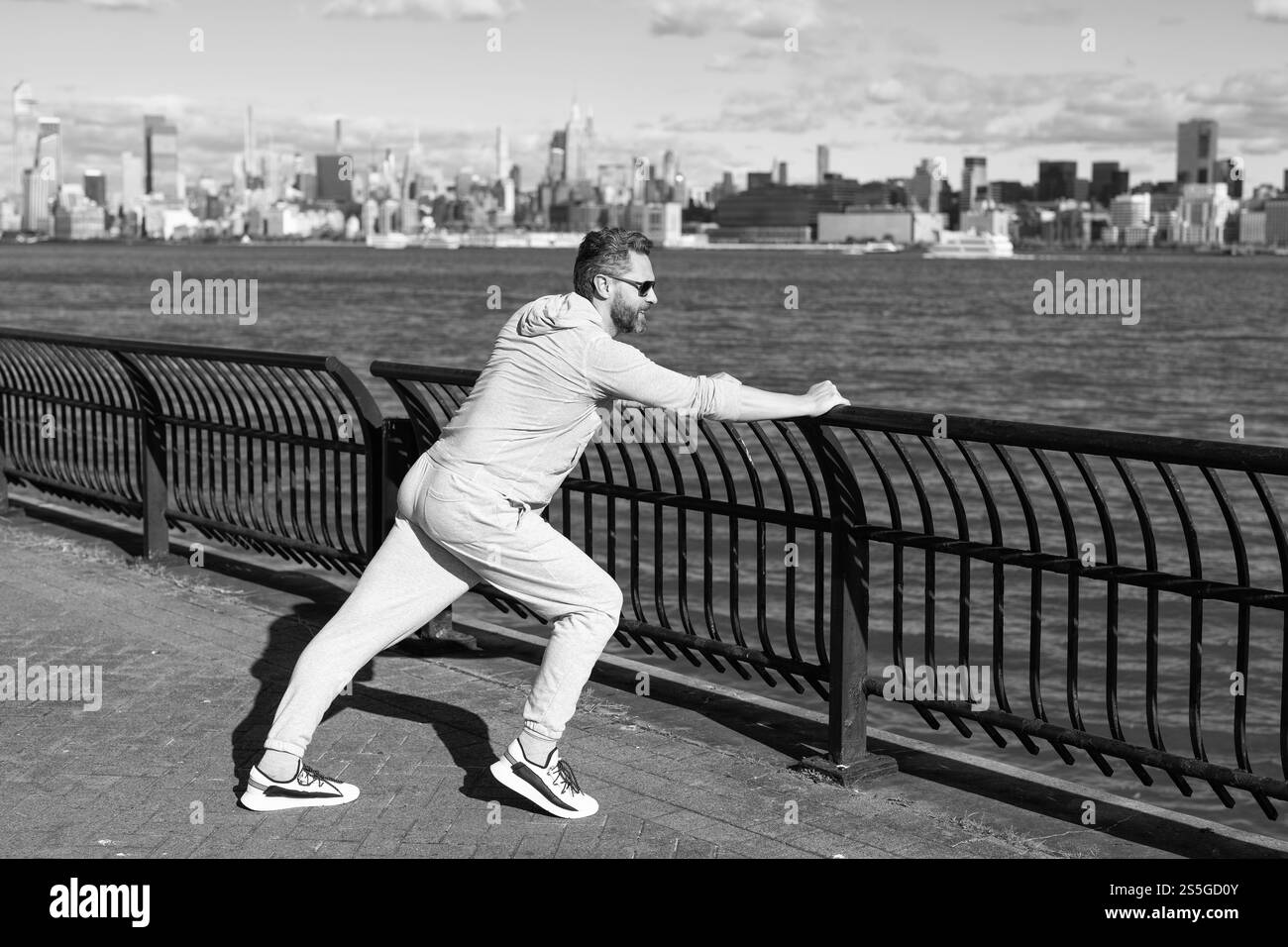 Stretching routine of sportsman outdoor in NY. Sportsman stretching ...