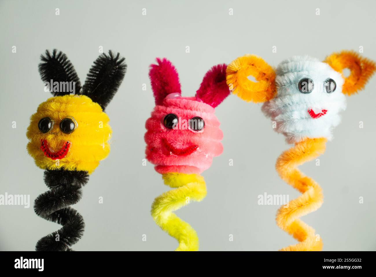 three sets of pipe cleaner finger puppets with colorful bulging eyes ...
